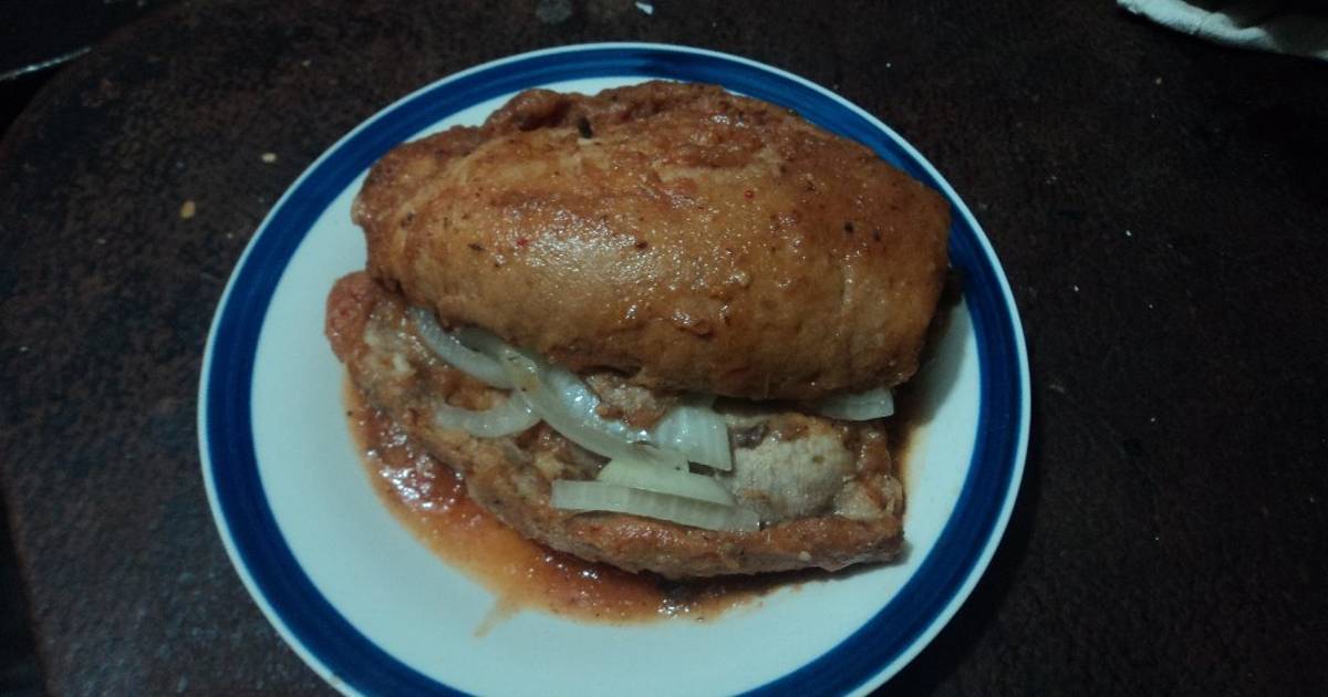 Torta bañada en jitomate, carnitas de cerdo con cebolla desflemada ...