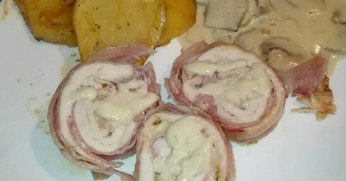Rollo de pechuga envuelto en beicon y relleno de jamón York y queso con ...