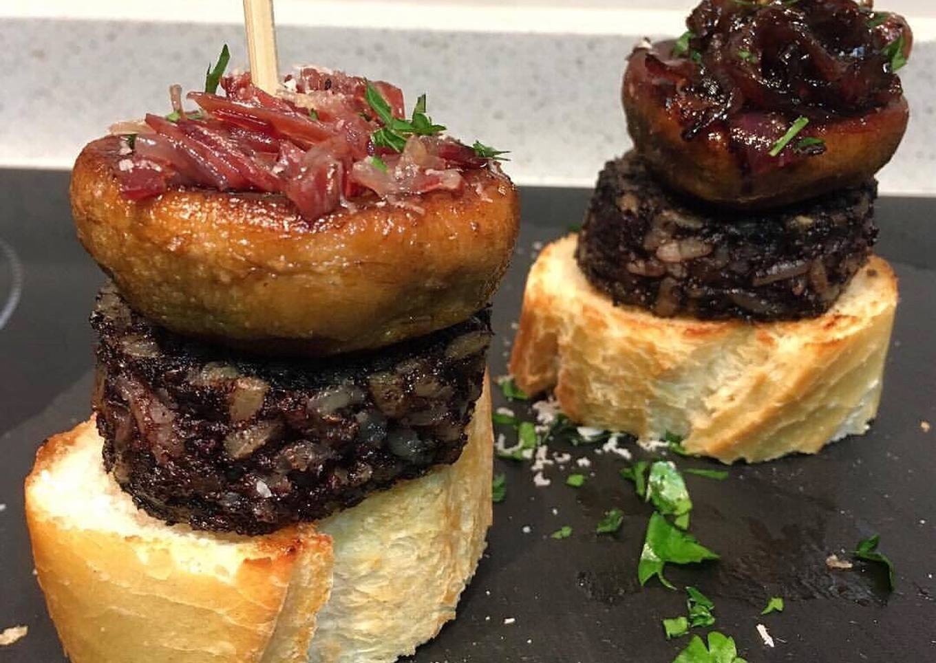 Pintxo de champi relleno de jamón ibérico y cebolla morada caramelizada ...